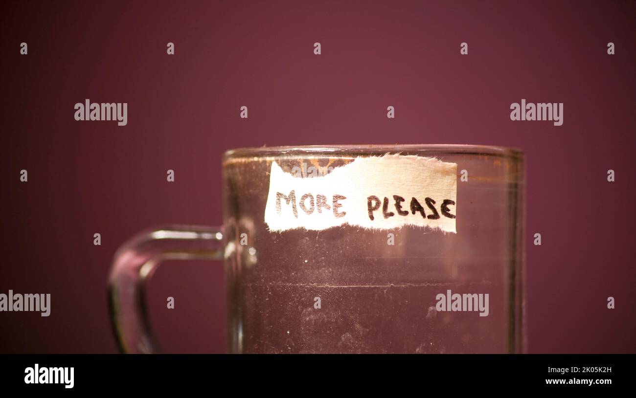 empty drinking glass of coffee with text word more please written on ...