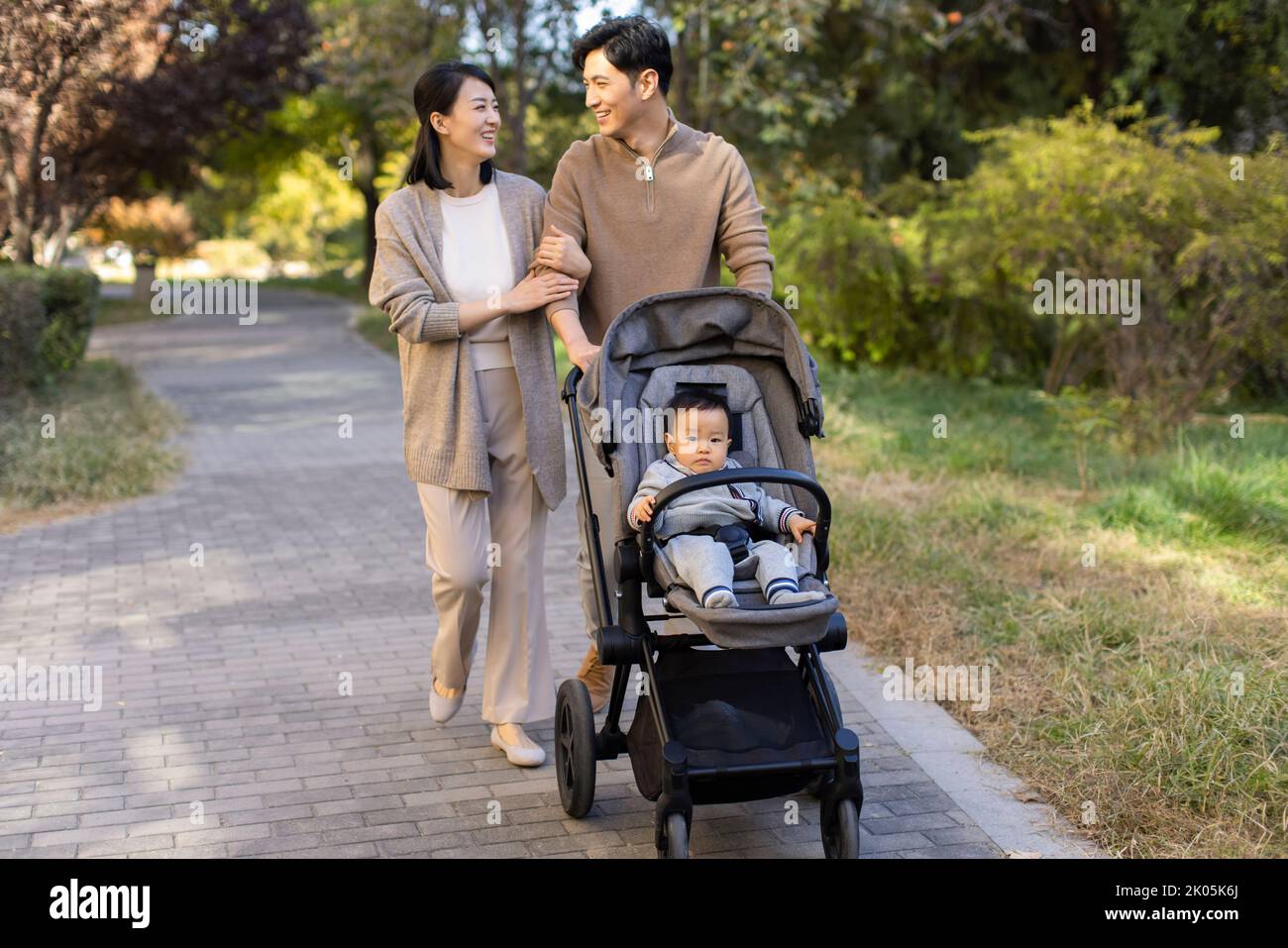 Young Chinese parents with baby in stroller Stock Photo - Alamy