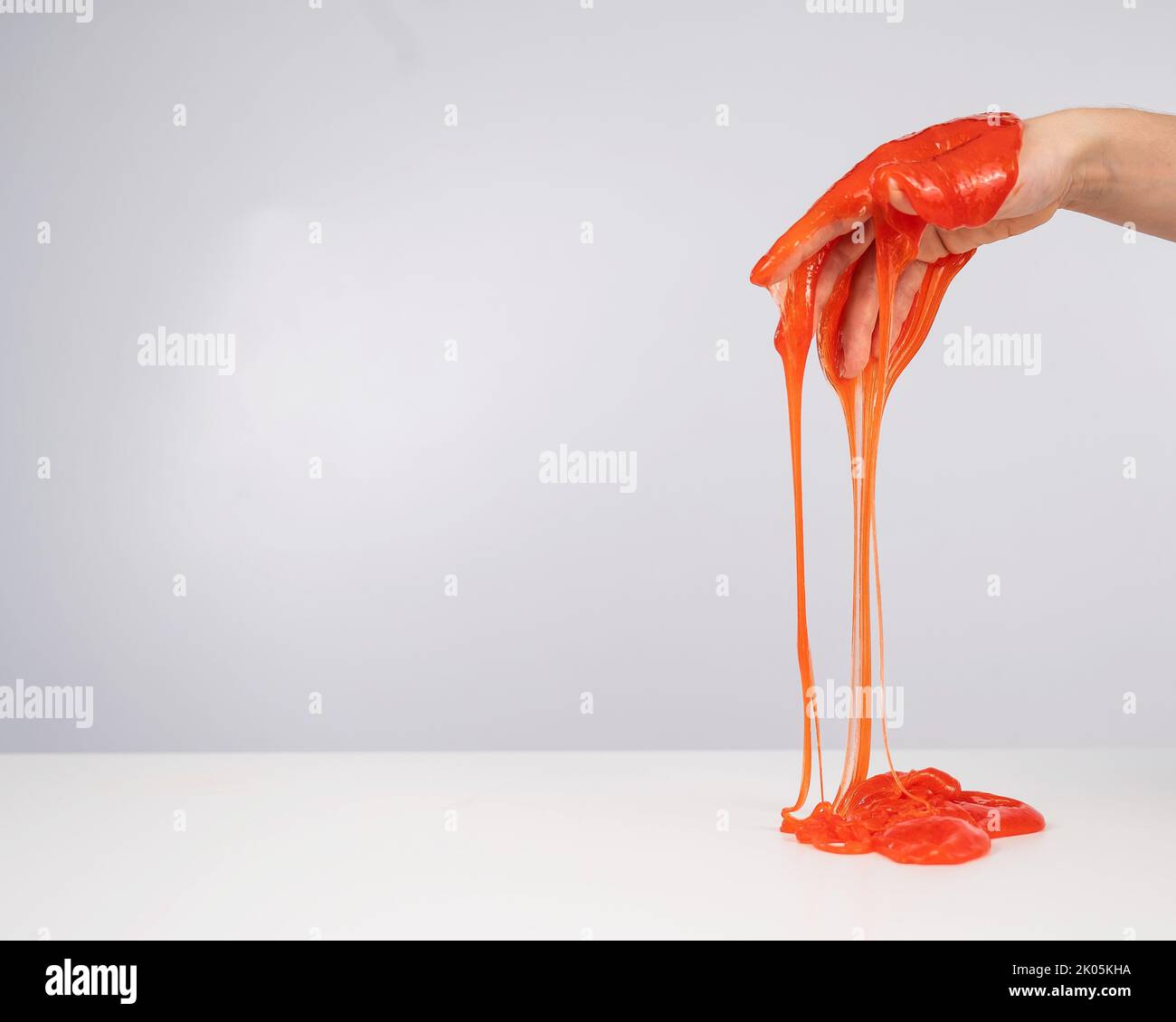 Red slime flowing down from a woman's hand on a white background Stock ...