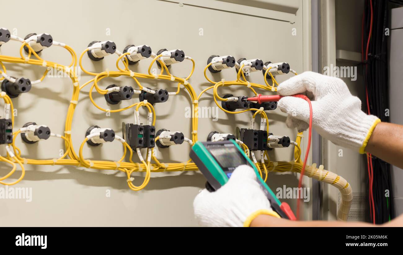 Electrical engineer tests the operation of the electric control cabinet ...