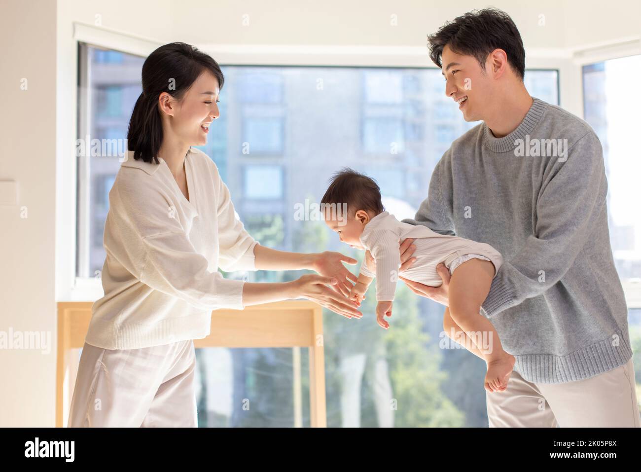 Young Chinese parents playing with baby at home Stock Photo - Alamy