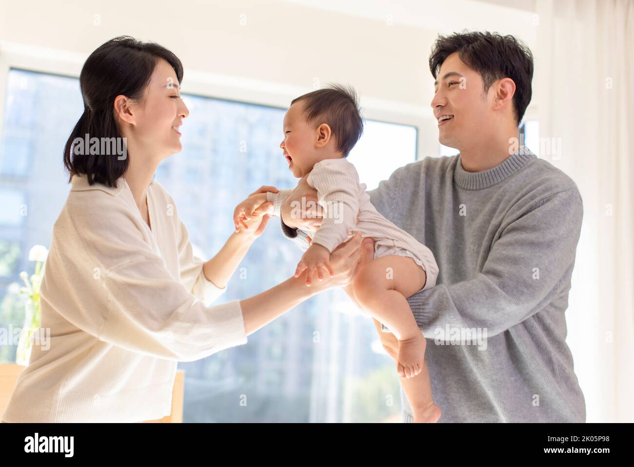 Young Chinese parents playing with baby at home Stock Photo - Alamy