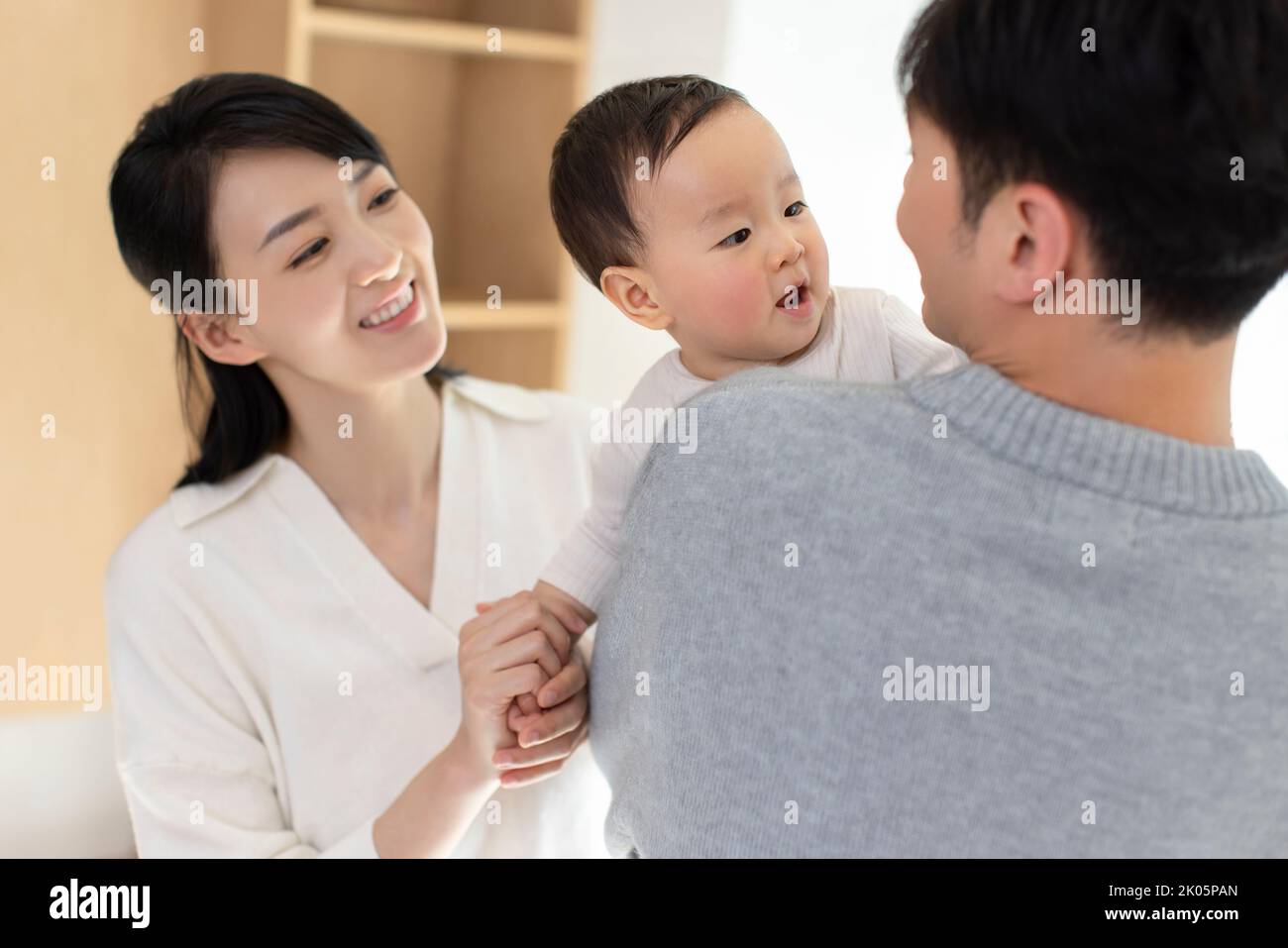 Young Chinese parents playing with baby at home Stock Photo - Alamy