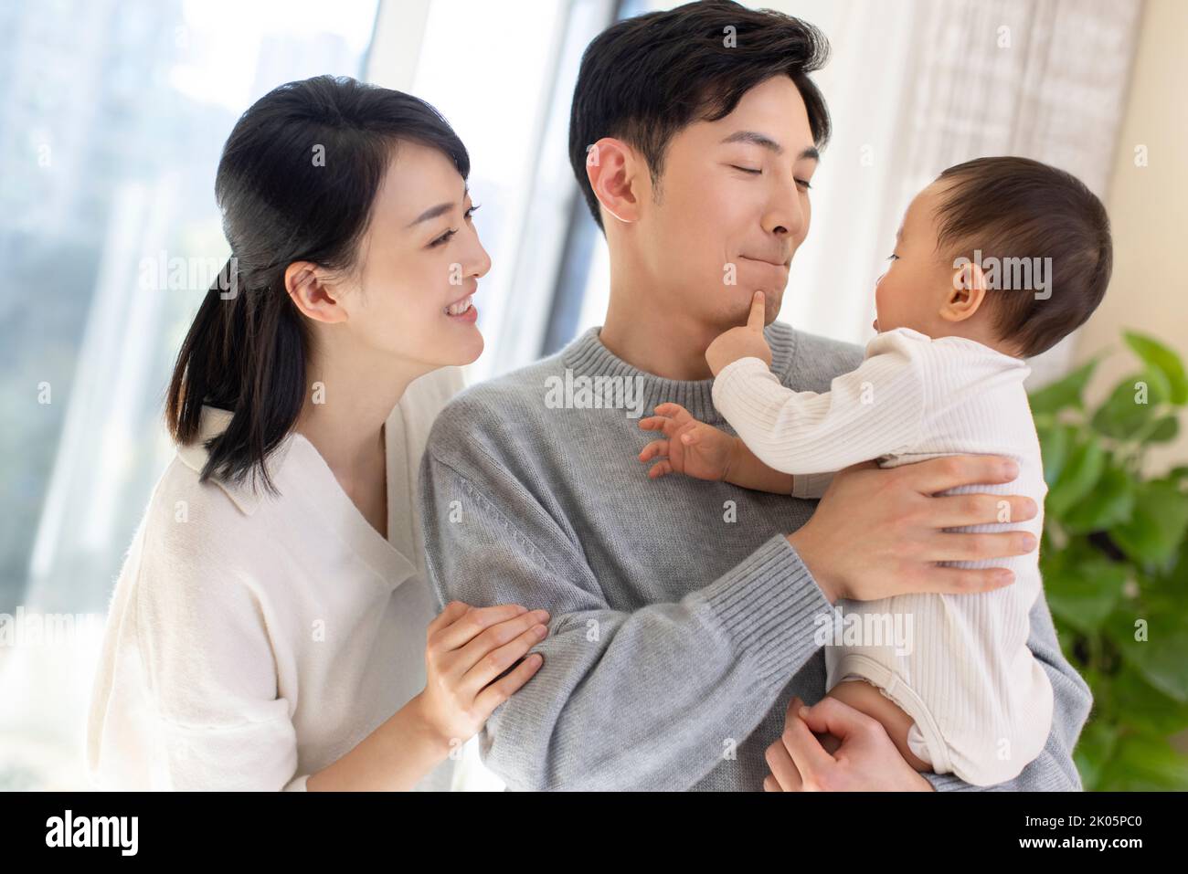 Young Chinese parents playing with baby at home Stock Photo - Alamy