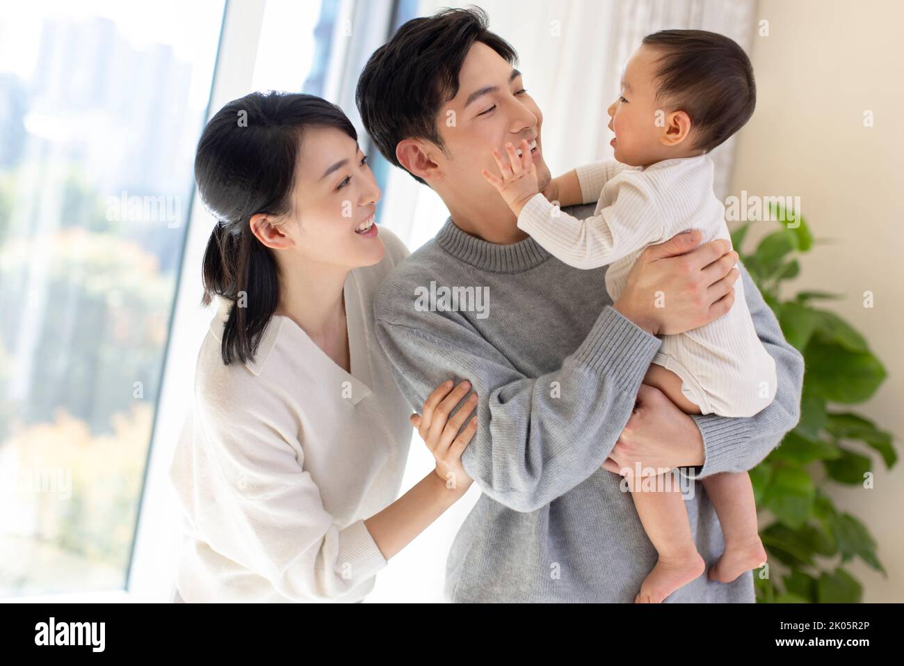 Young Chinese parents playing with baby at home Stock Photo - Alamy