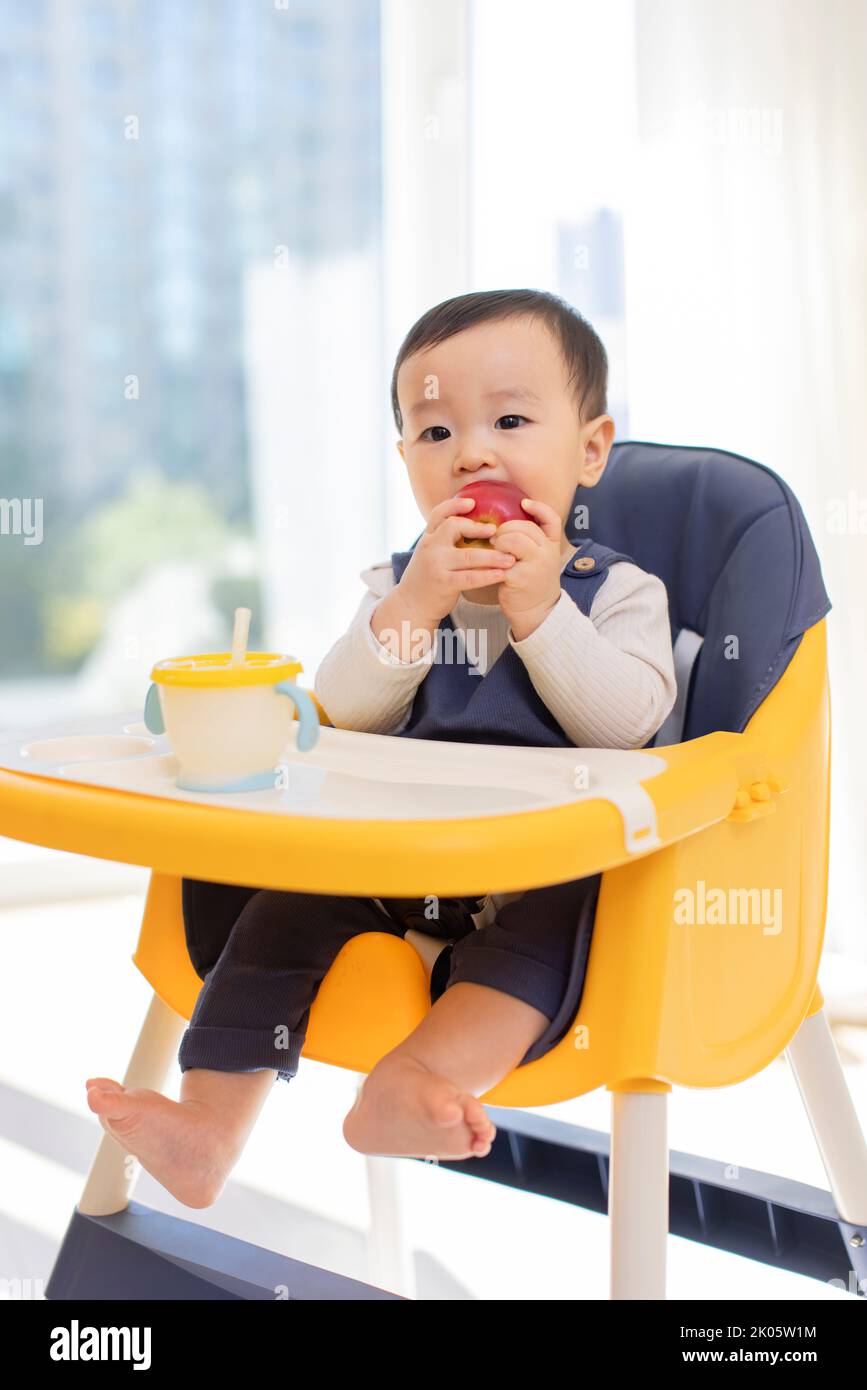Cute Chinese baby sitting in high chair Stock Photo - Alamy