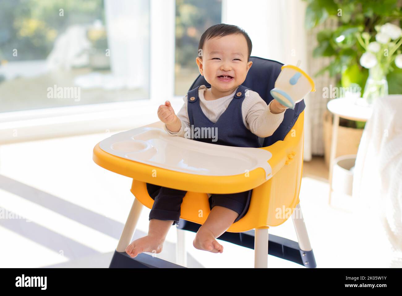 Cute Chinese baby sitting in high chair Stock Photo - Alamy