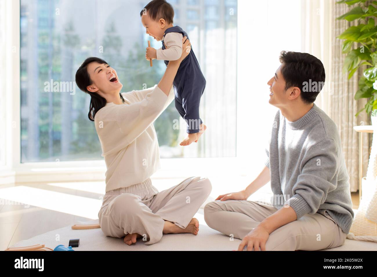 Young Chinese parents playing with baby at home Stock Photo - Alamy