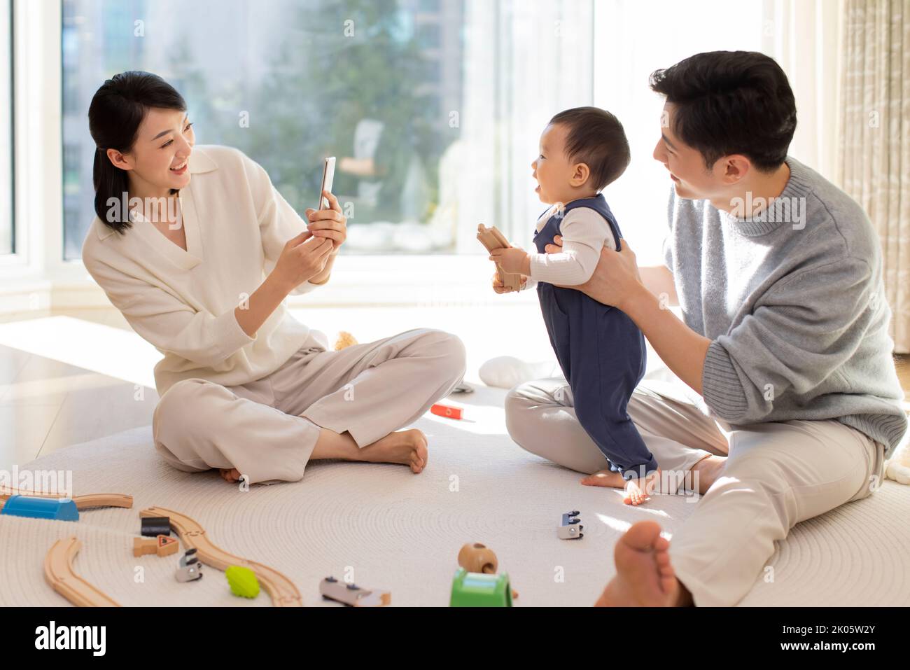 Young Chinese parents playing with baby at home Stock Photo - Alamy