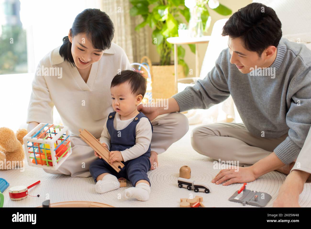 Young Chinese parents playing with baby at home Stock Photo - Alamy