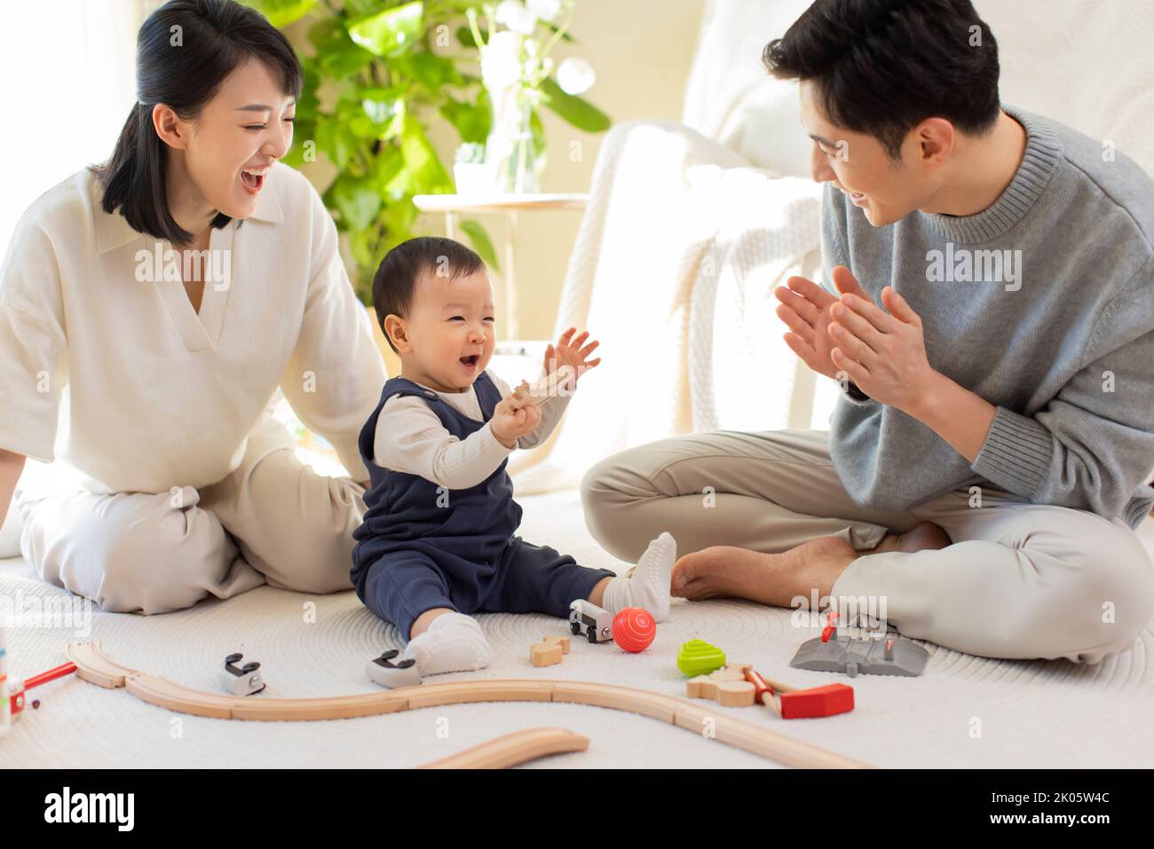 Young Chinese parents playing with baby at home Stock Photo - Alamy