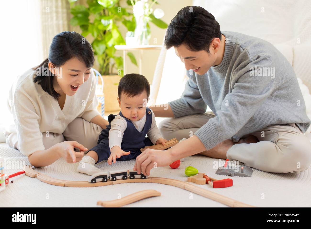Young Chinese parents playing with baby at home Stock Photo - Alamy