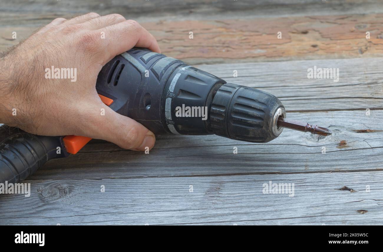 Humand handusing screwdriver on wooden table - From above of crop ...
