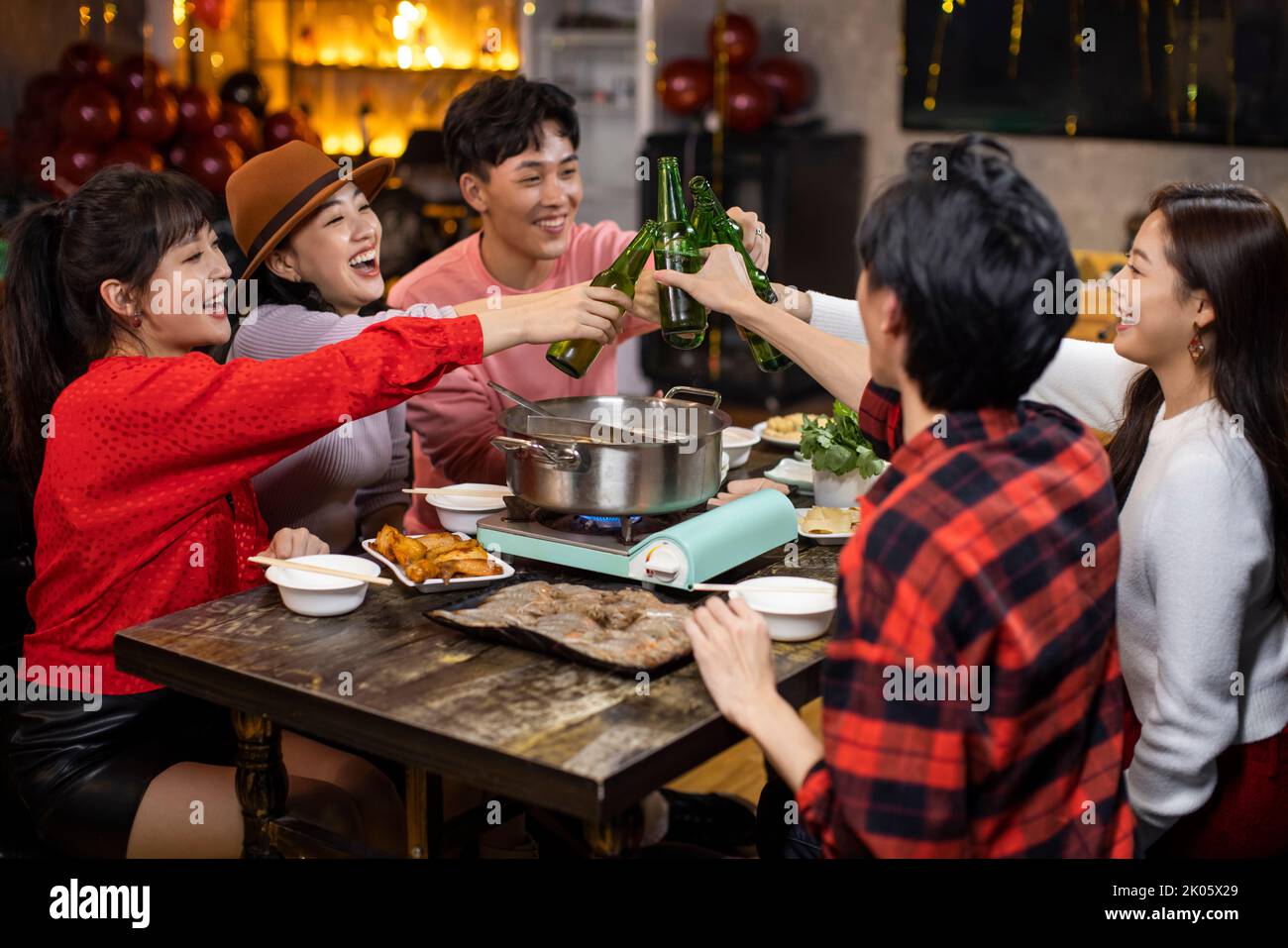 Young Chinese friends drinking beer in hotpot restaurant Stock Photo ...
