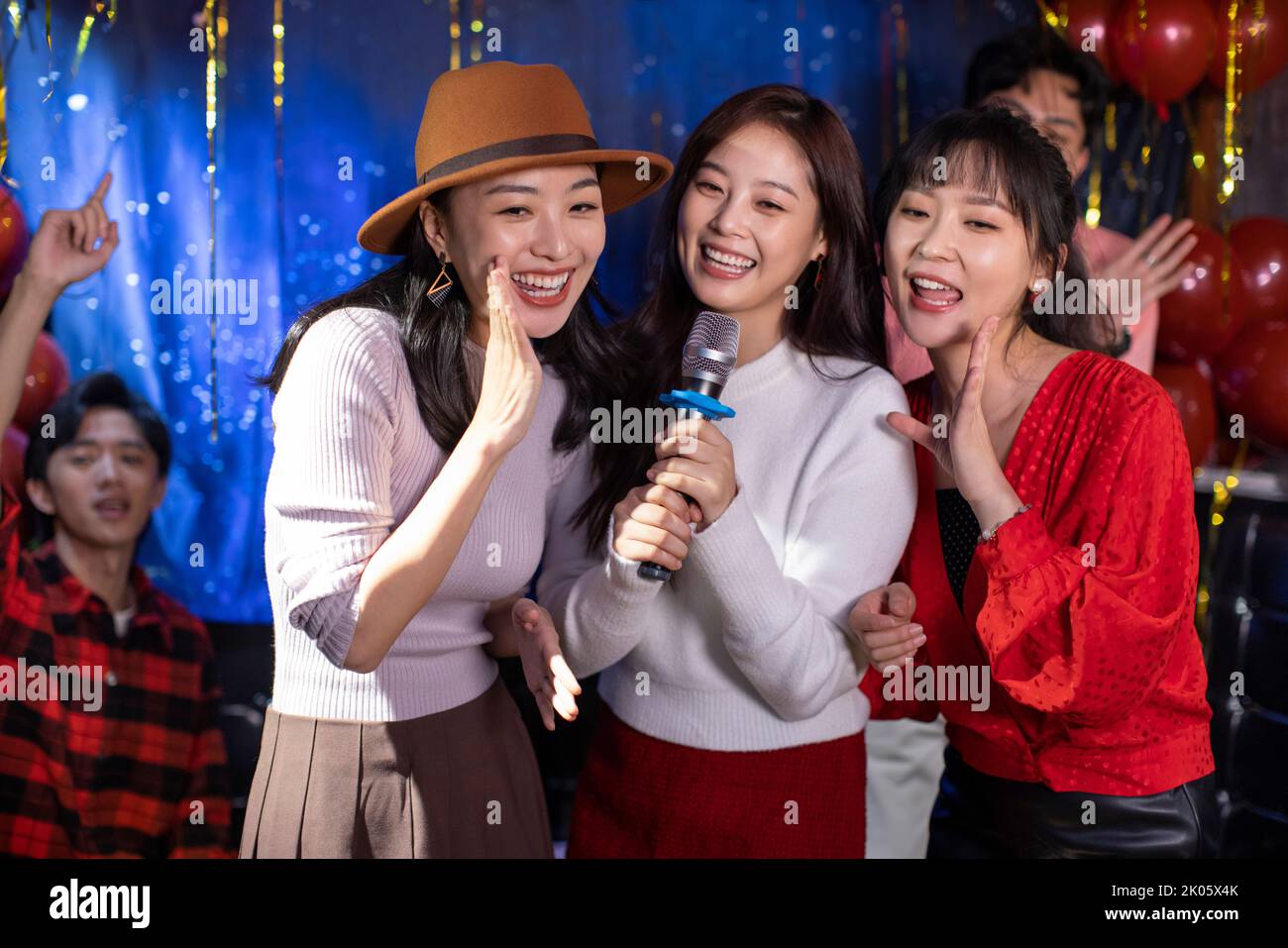 Happy young Chinese friends singing karaoke in nightclub Stock Photo ...