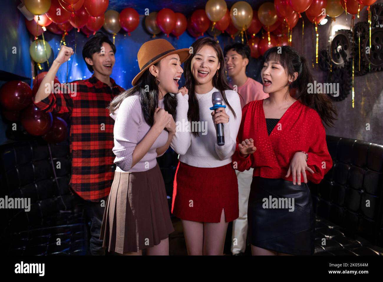 Happy young Chinese friends singing karaoke in nightclub Stock Photo ...