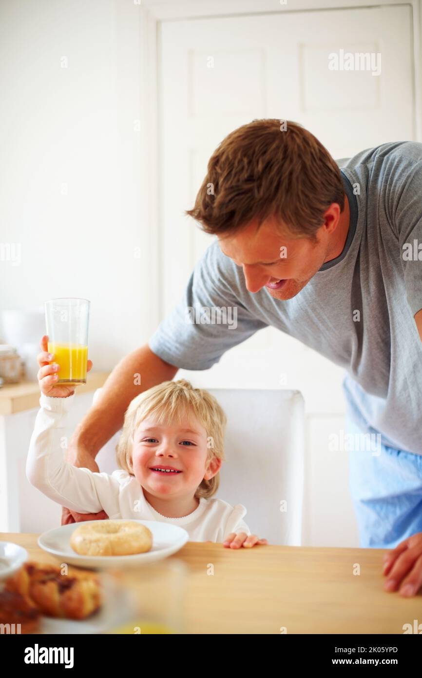 Happy little boy with his father holding glass of juice. Portrait of a ...