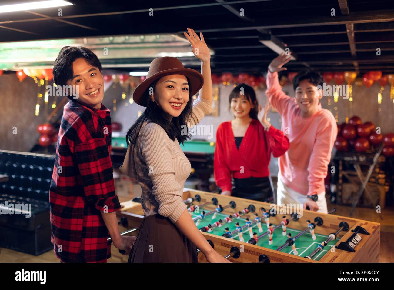 Happy young Chinese friends playing table football Stock Photo - Alamy