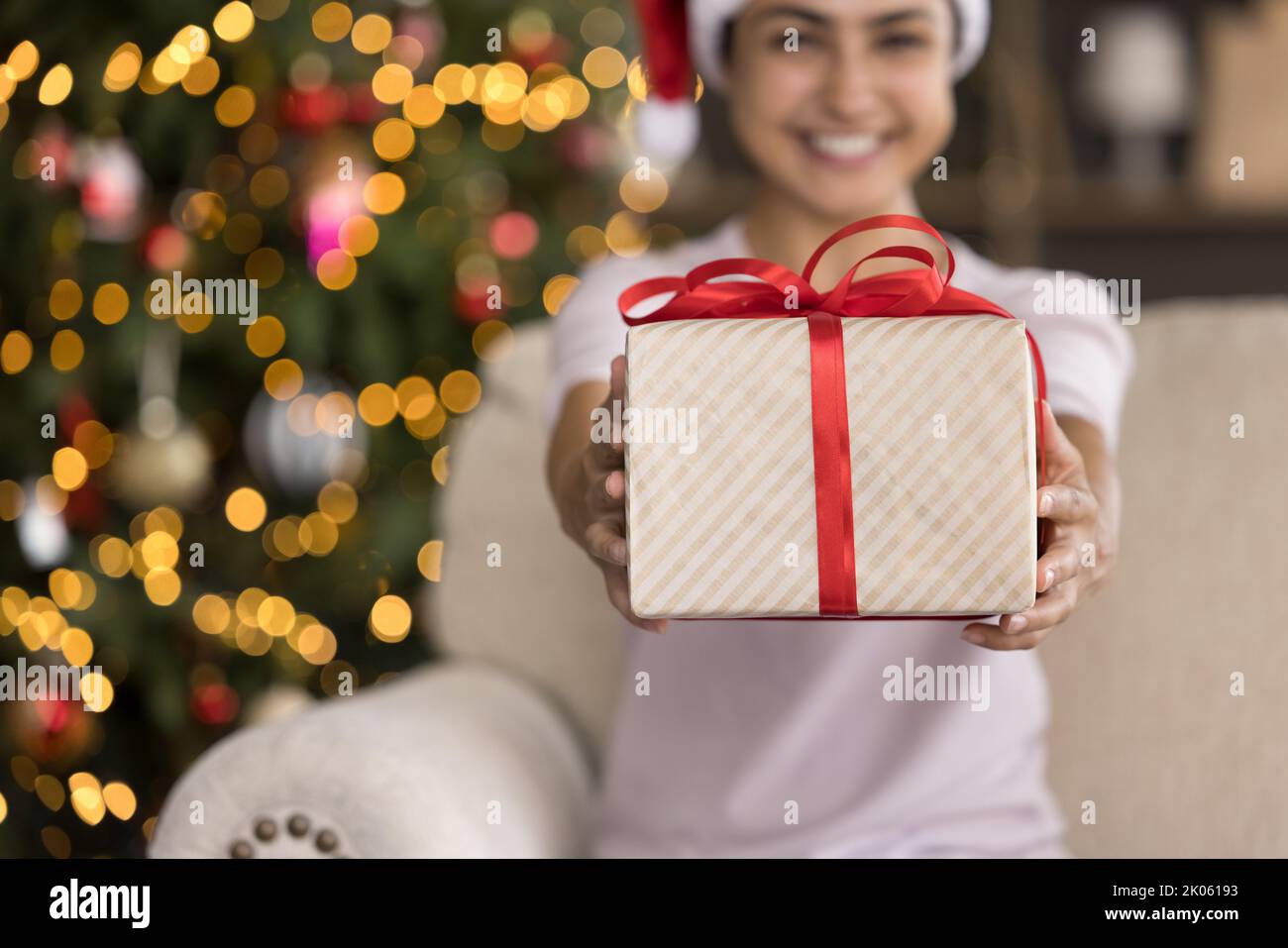 Xmas gift wrap with red ribbon in hands close up Stock Photo - Alamy