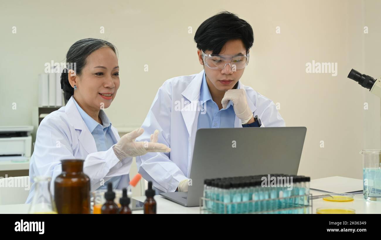 Professional scientist team conducting experiment in laboratory ...