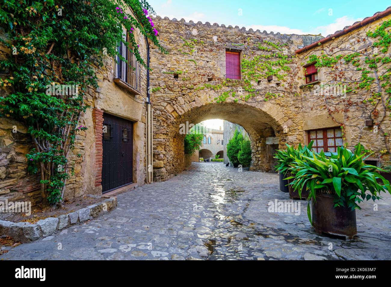 Picturesque alley with stone arches and the sun appearing between the ...
