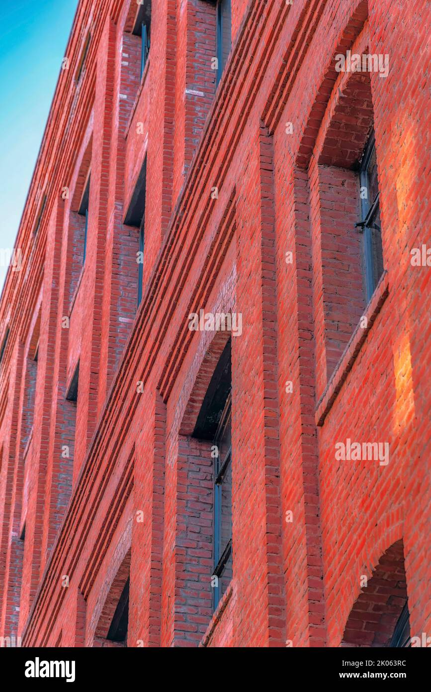Exterior view of a contemporary building with red brick wall and arched ...