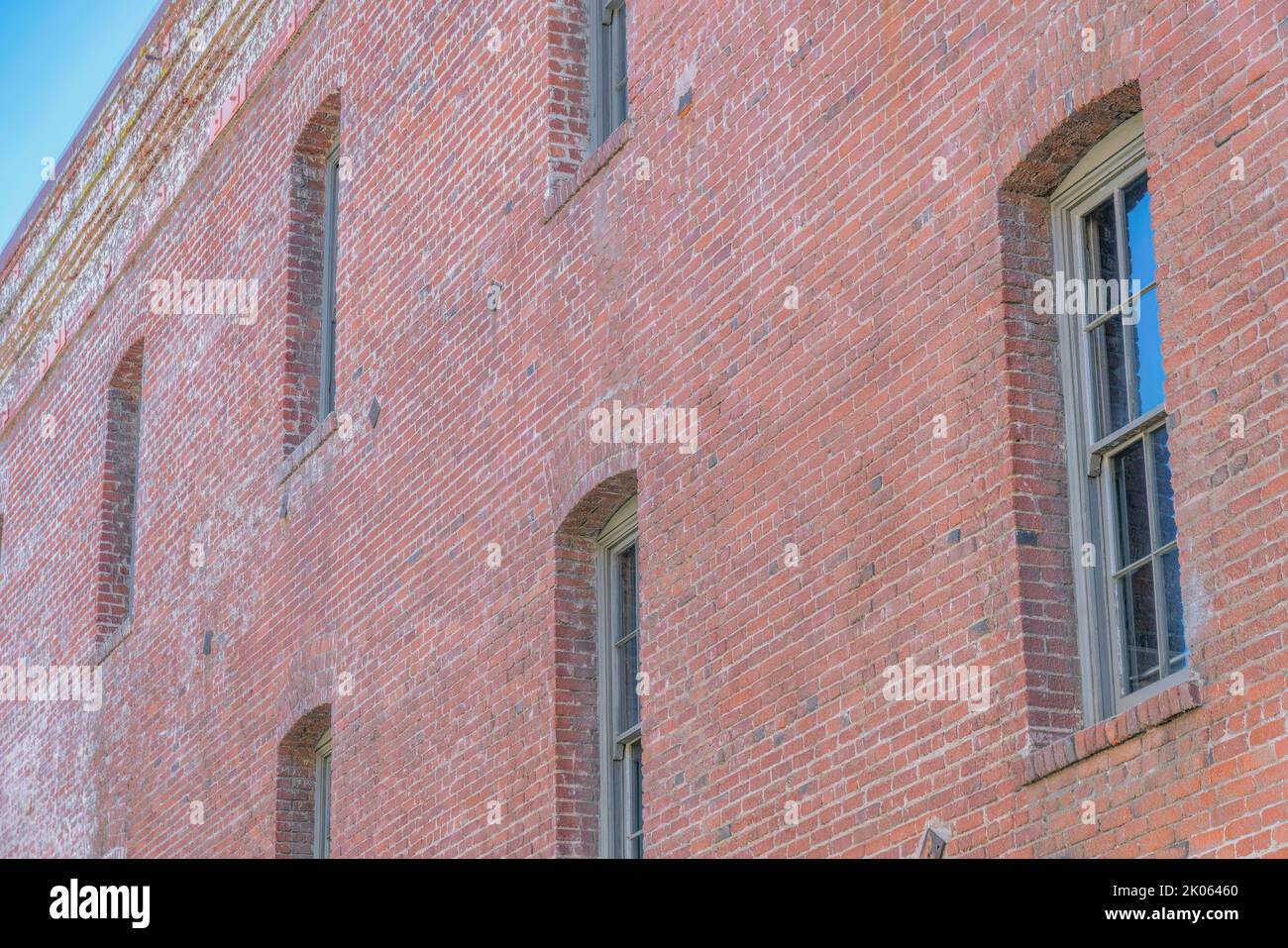 Red brick wall and arched windows at the exterior of residential home ...