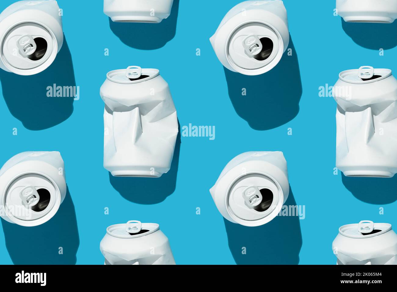Crushed white beverage cans pattern on the bright blue background ...