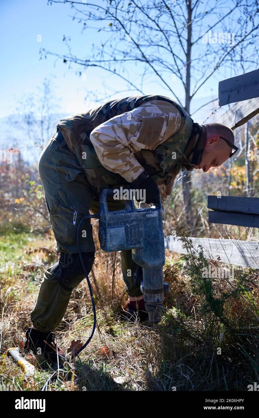 Male worker building pile foundation for wooden frame house. Man ...