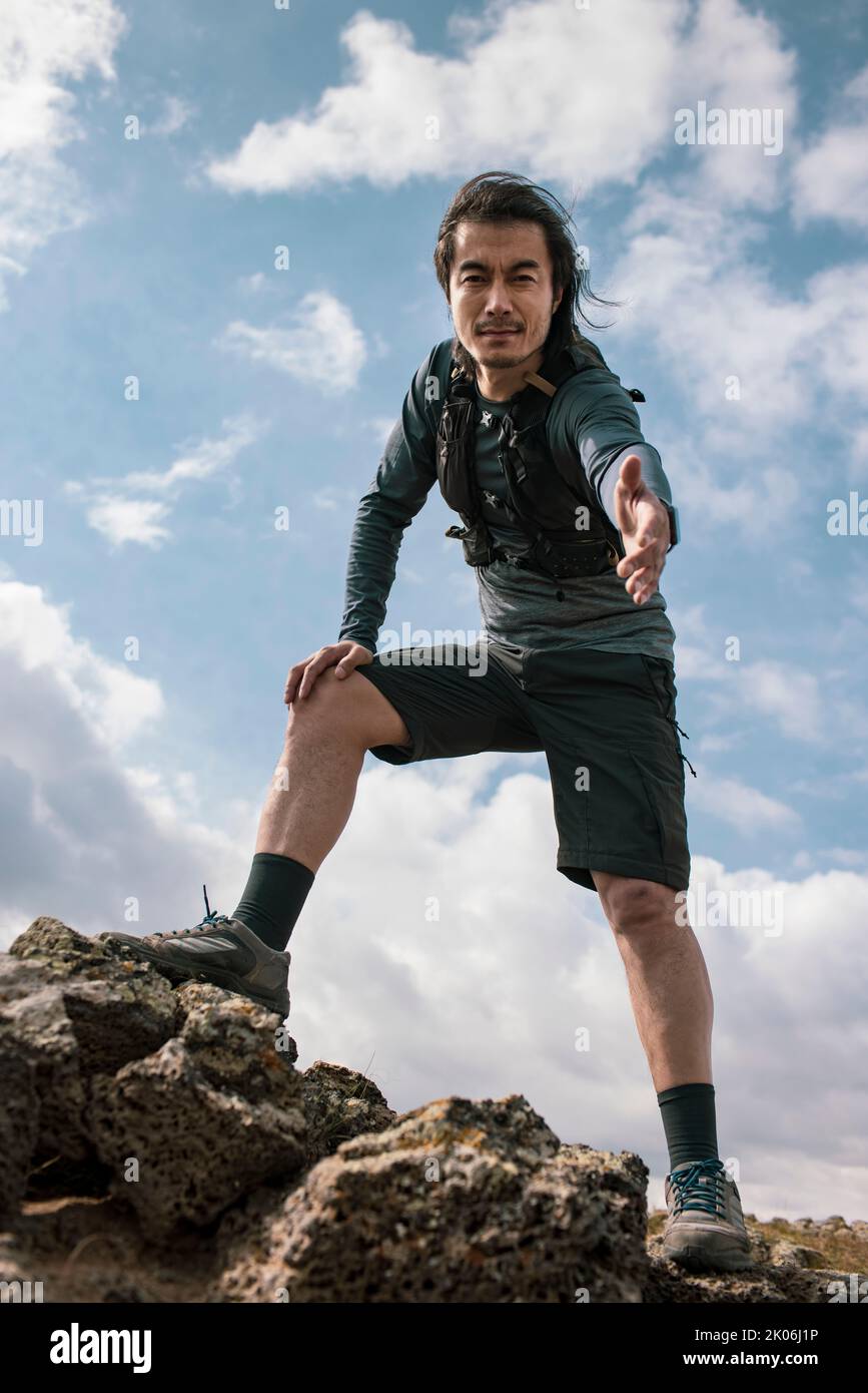 Chinese male trail runner standing on rock Stock Photo - Alamy