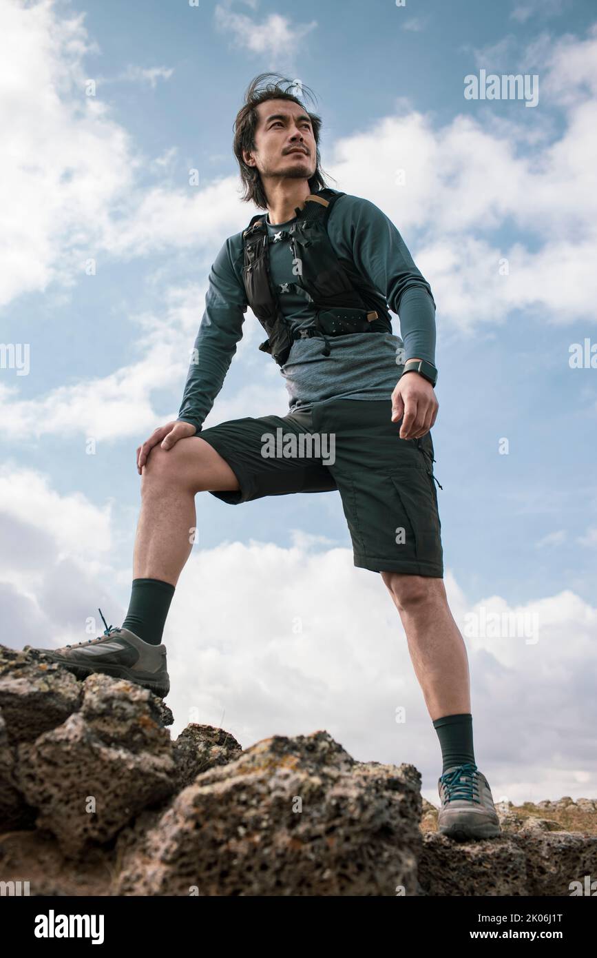 Chinese male trail runner standing on rock Stock Photo - Alamy