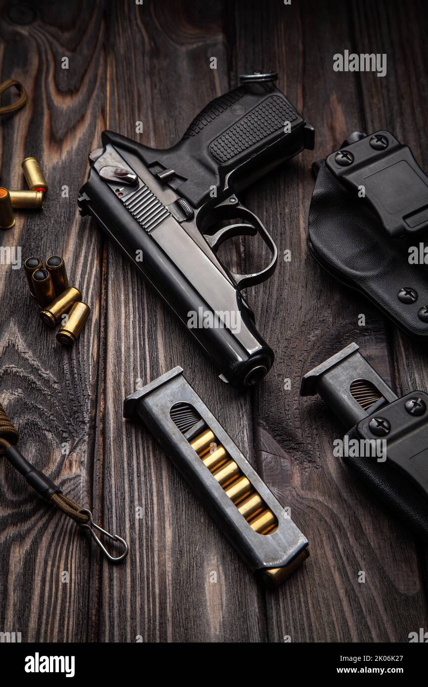 A modern black pistol and ammunition on dark metal background. Weapons ...