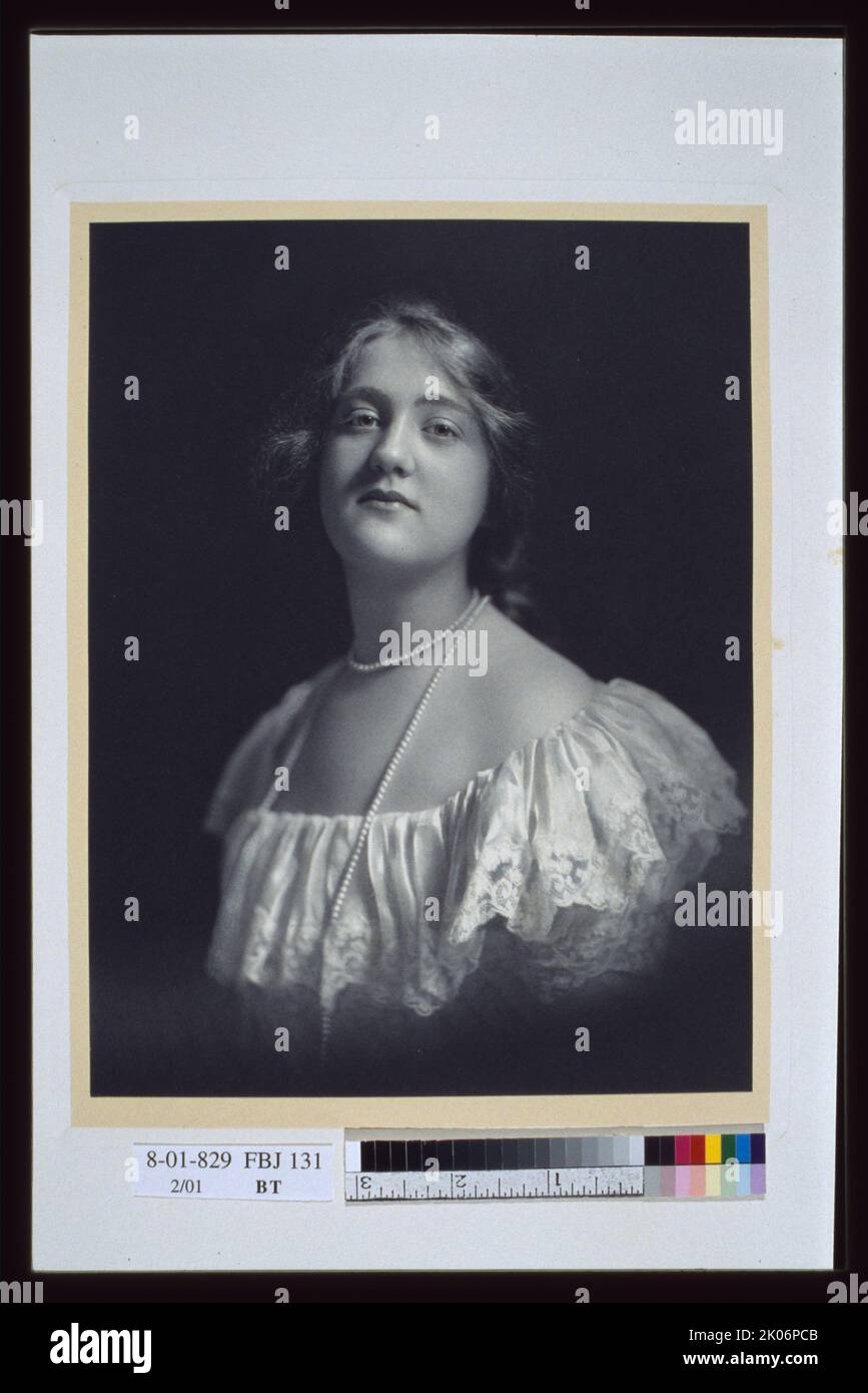 Young woman wearing an off-the-shoulder dress and long pearl necklace ...