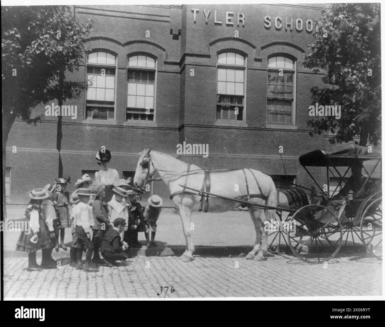 Children studying a horse and buggy outside the Tyler School ...