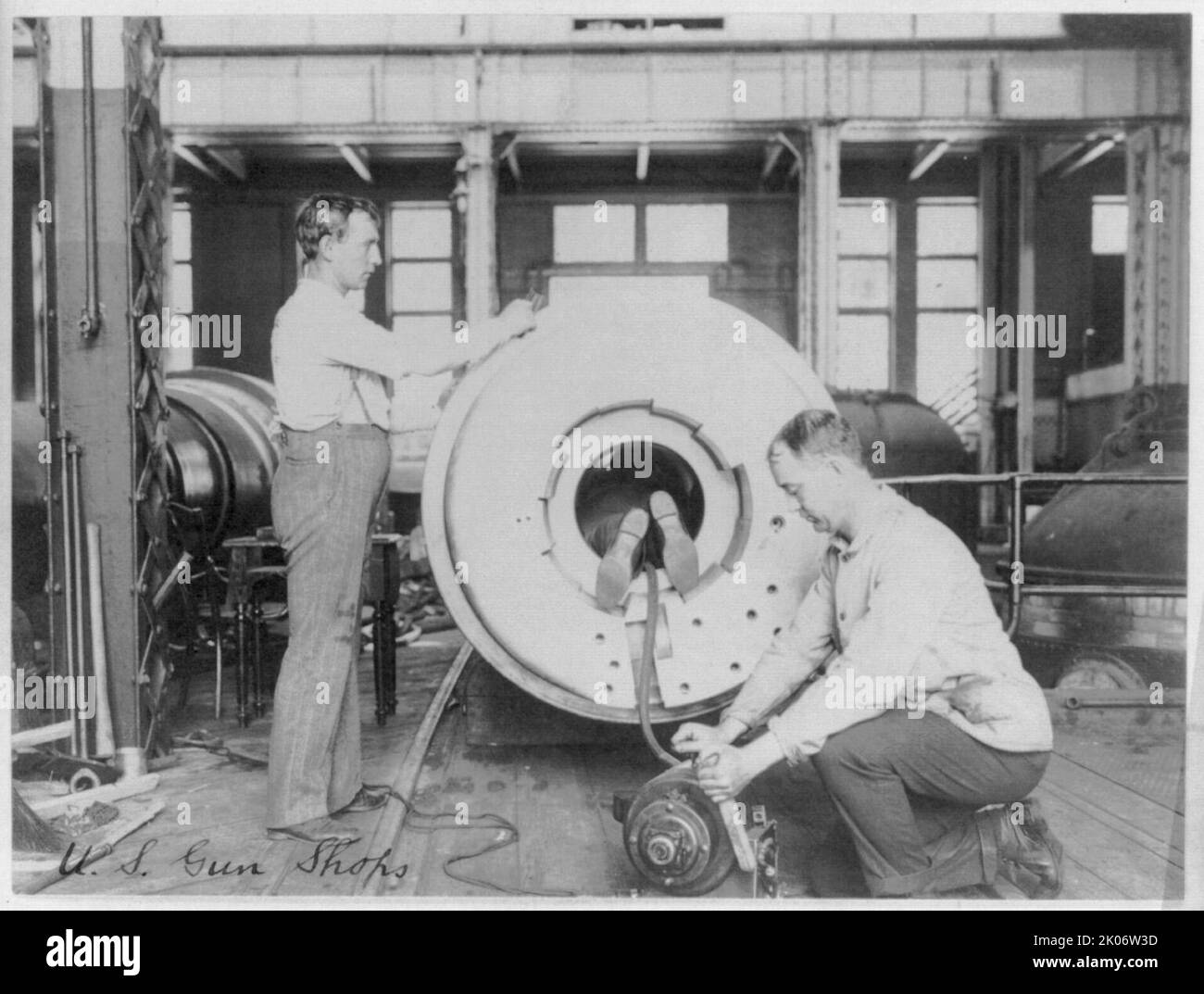 Three men working on large gun in Naval Gun Factory, Washington, D.C ...