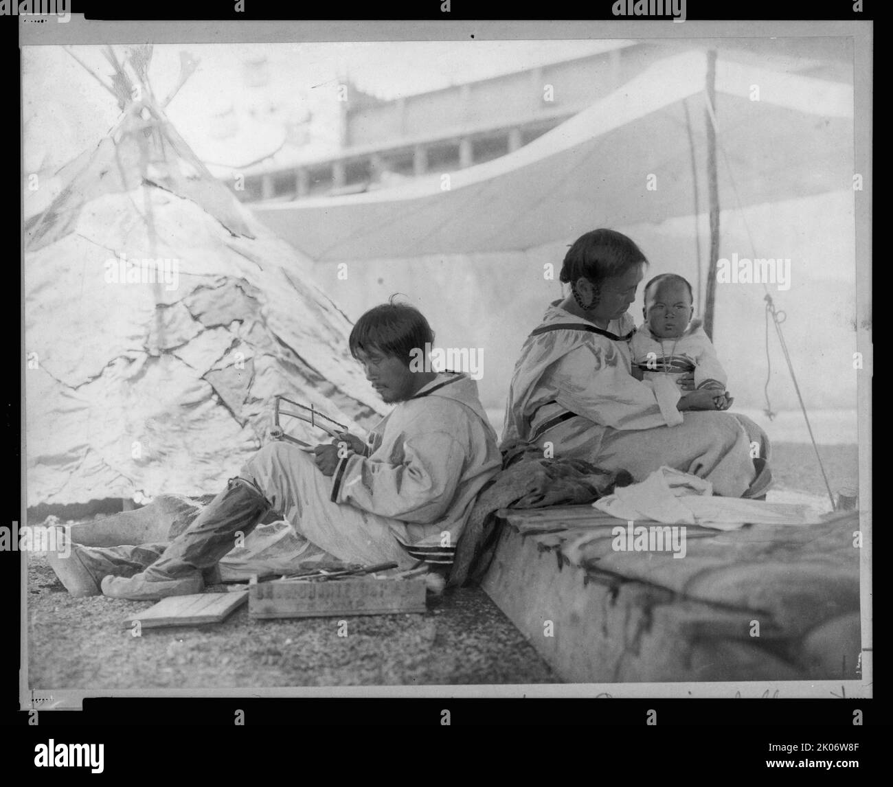 Esquimaux village, 1901. Photograph shows Eskimo man, woman, and baby ...