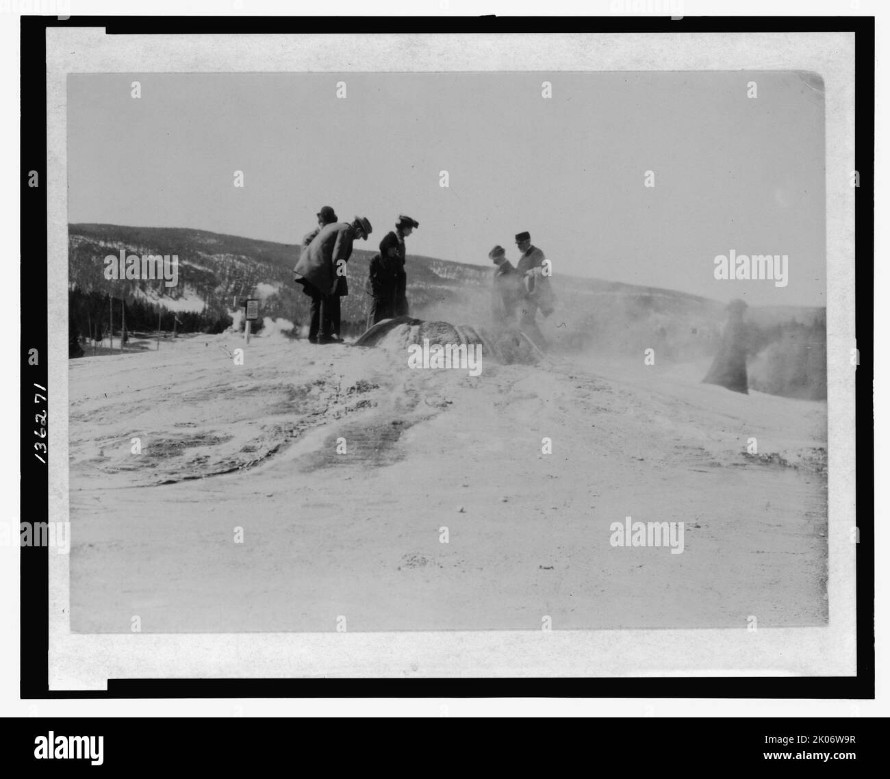 A group of tourists explore a geyser in the Upper Geyser Basin in ...