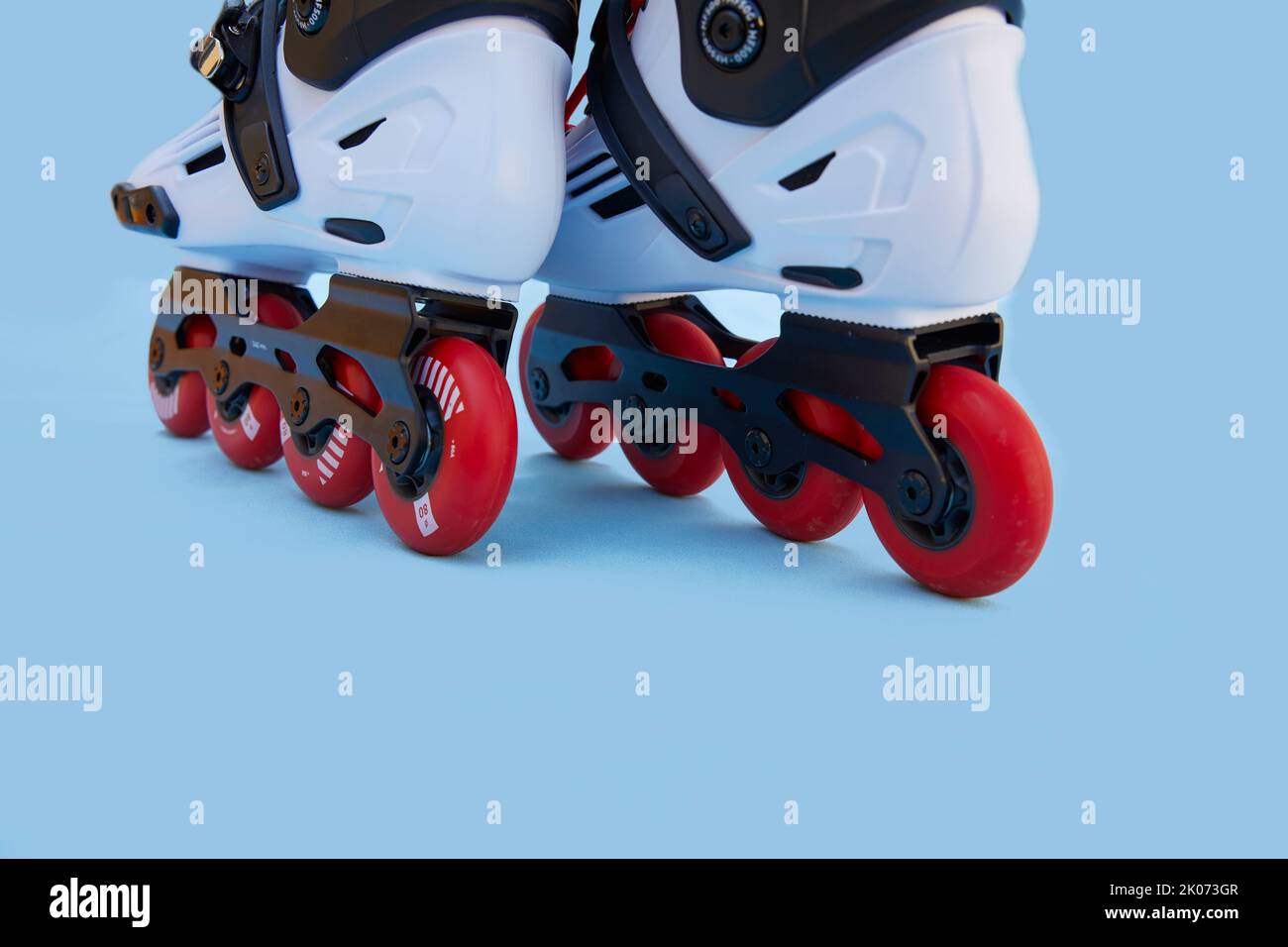 Rear side of inclined inline skates walking on blue background with ...