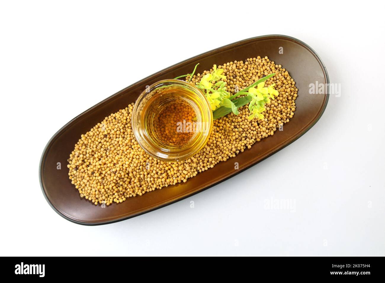 mustard seed, oil and flower on white background. useful in cooking and ...