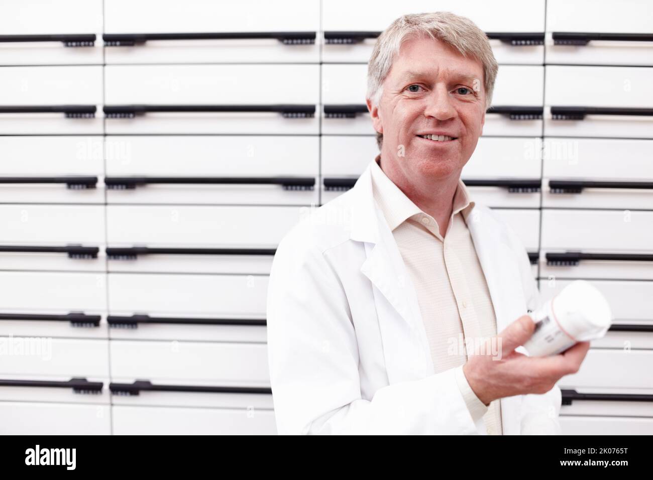 Smiling pharmacist at pharmacy. Portrait of handsome mature pharmacist ...