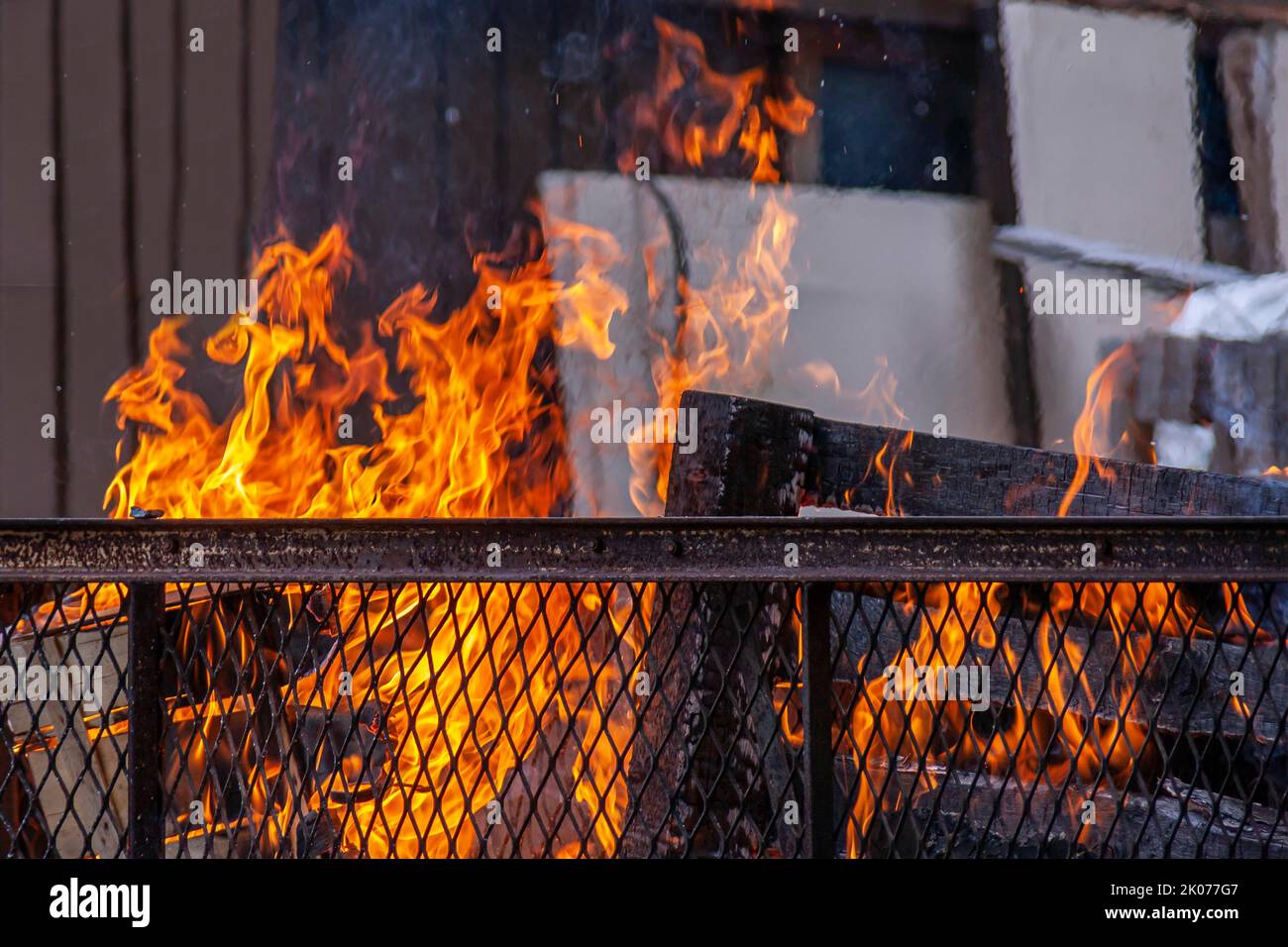 Fire, burning of waste, waste wood in lattice box Stock Photo - Alamy