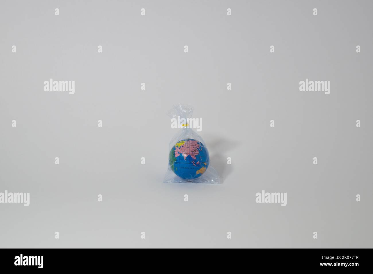 small earth inside plastic bag, pollution concept. white background ...