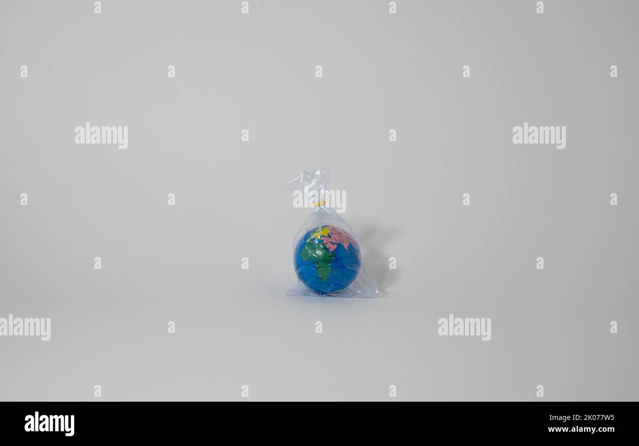 small earth inside plastic bag, pollution concept. white background ...