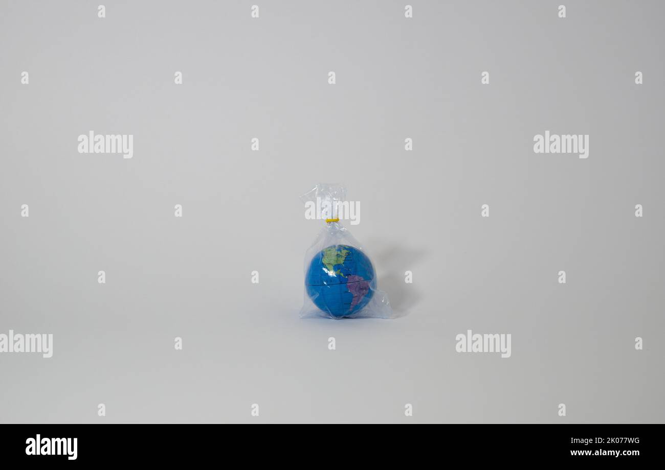 small earth inside plastic bag, pollution concept. white background ...