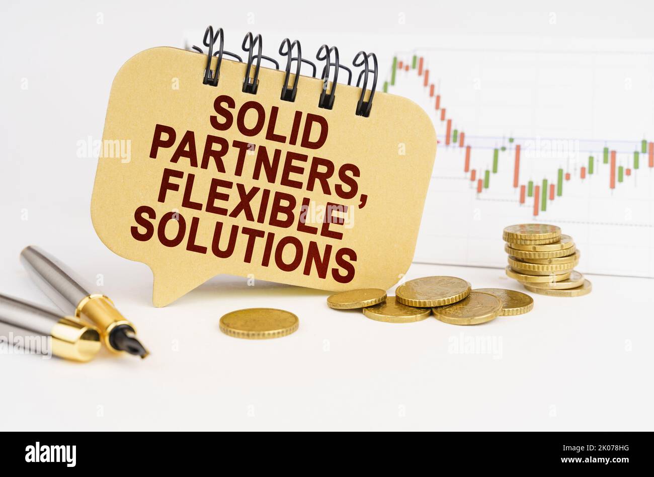Business concept. On the table are coins, a pen, a graph and a sign with the inscription - Solid ...