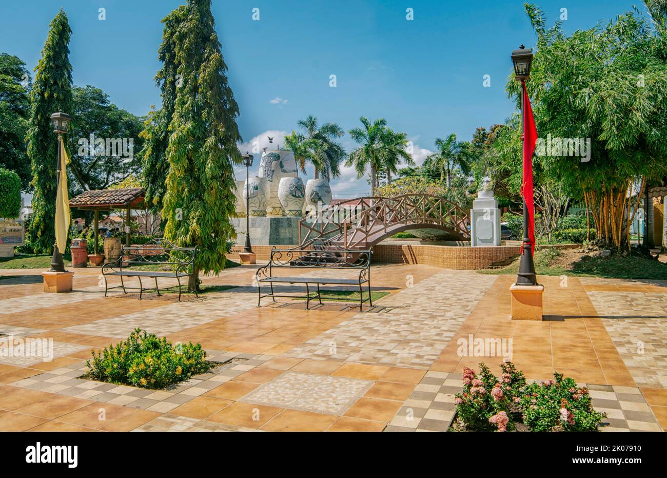 A nice and relaxed park with a wooden bridge over a water fountain ...