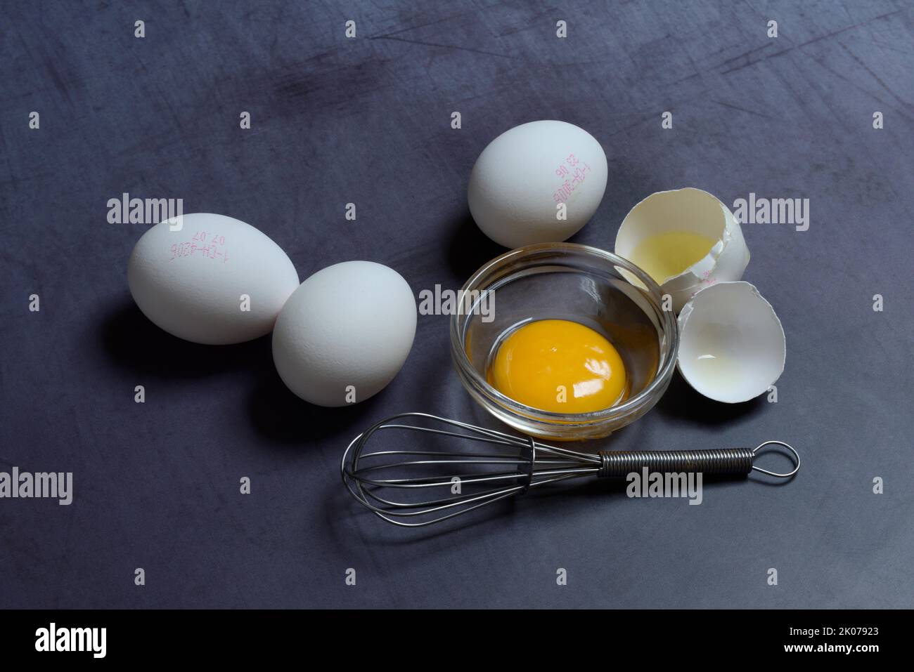 Egg yolks in small bowls and egg whites in egg shells, whisk Stock ...