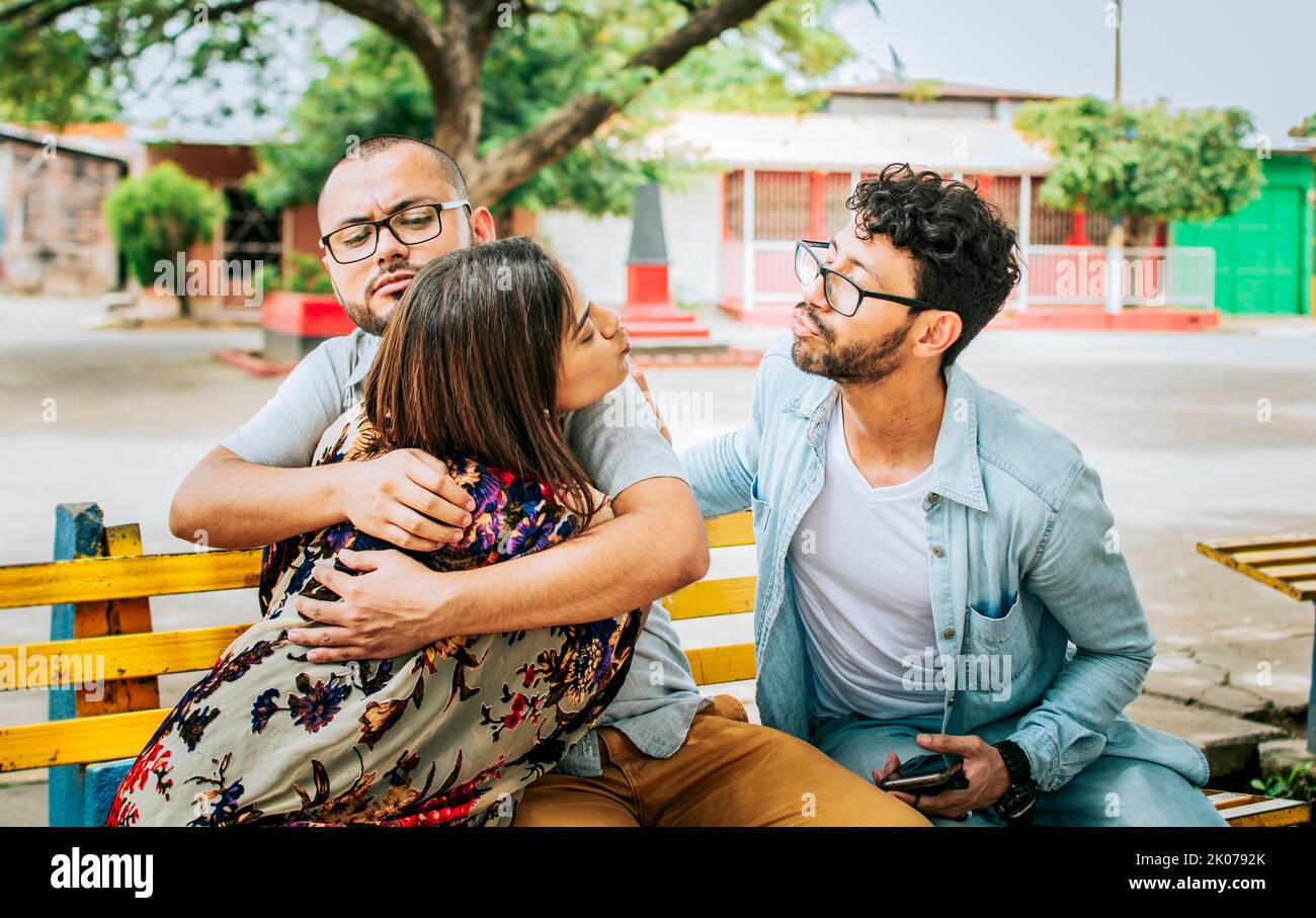 Disloyal girlfriend hugging her boyfriend in a park secretly kissing ...