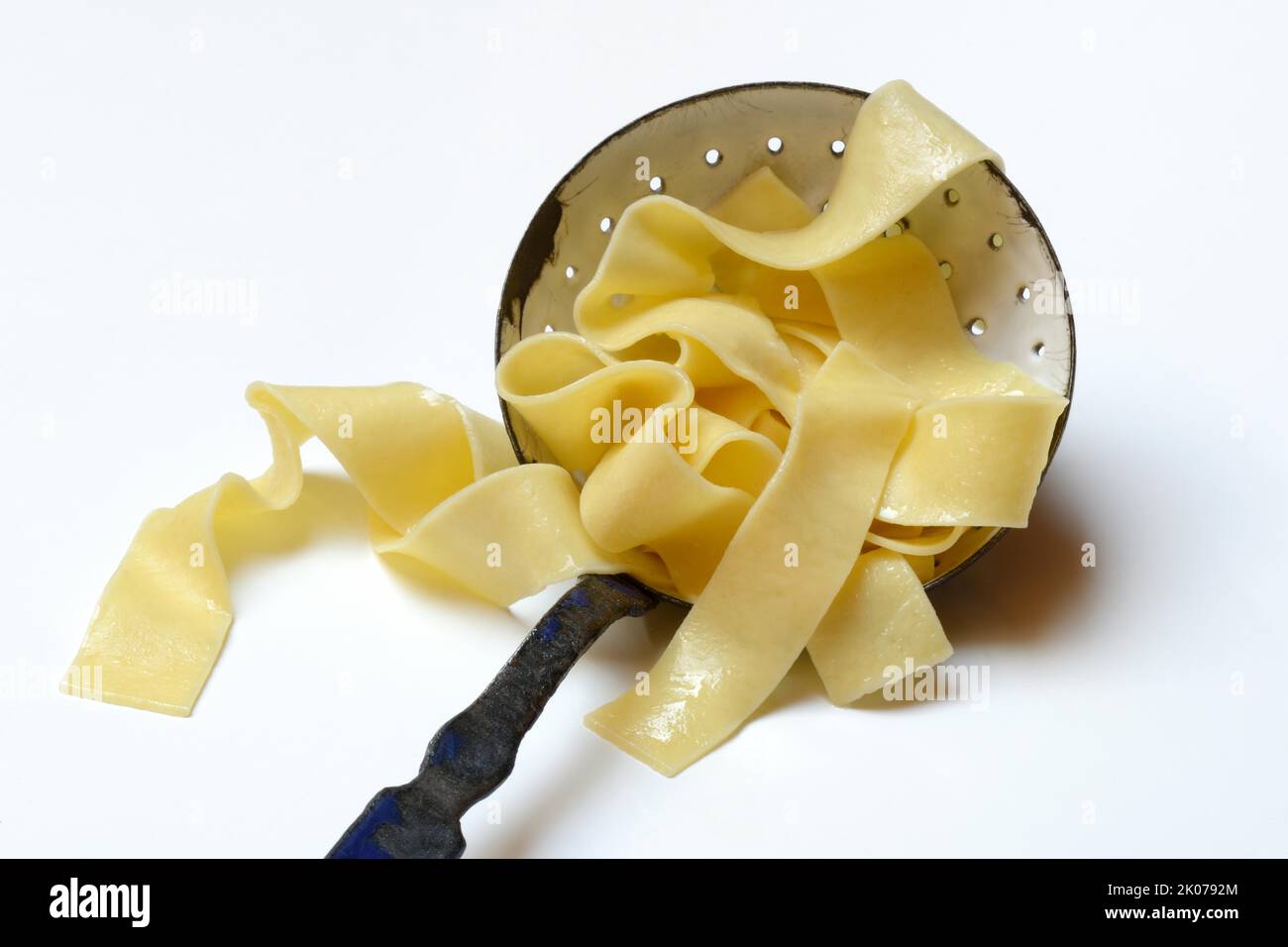 Pappardelle, wide Italian ribbon noodles in a sieve ladle, pasta ...