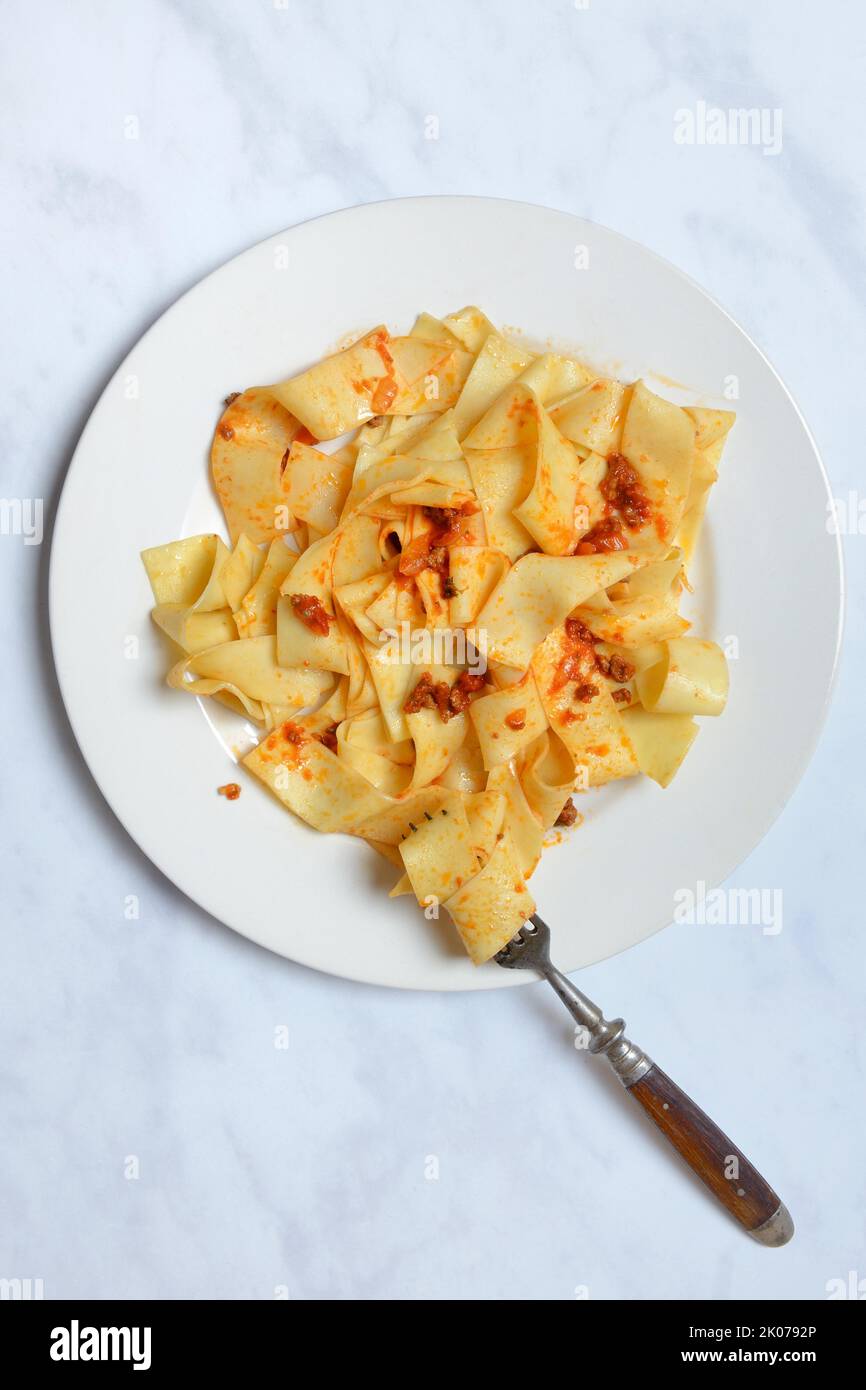 Pappardelle, cooked, wide Italian ribbon noodles with Bolognese sauce ...